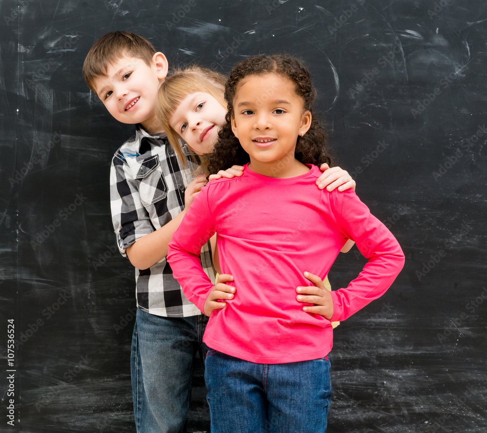 three different children stand one by one peeking out from behind each ...