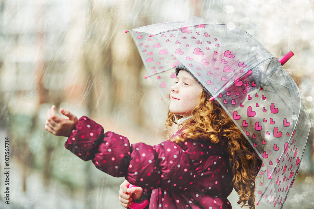 Little girl stretches her hand to catch falling raindrop. Stock Photo ...