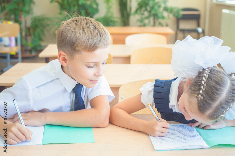 Students or classmates in school classroom sitting together at desk ...