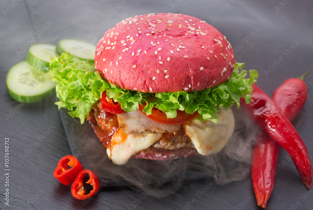 big red hamburger with smoke on a slate table Stock Photo | Adobe Stock