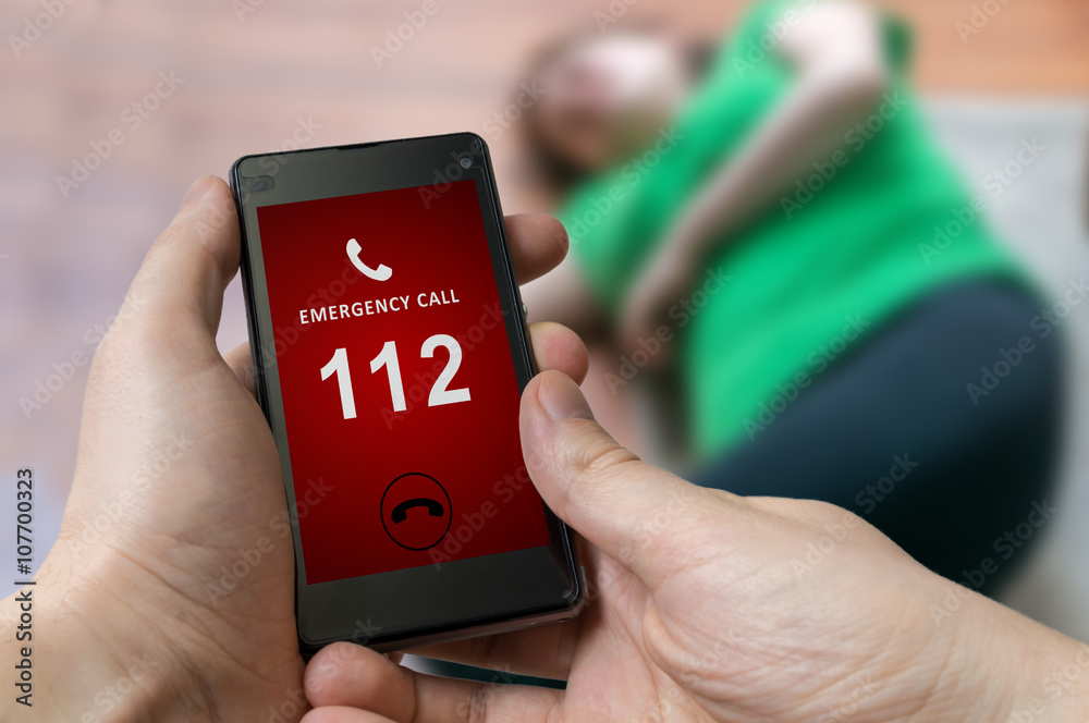 Man dialing emergency (112 number) on smartphone. Woman had heart ...
