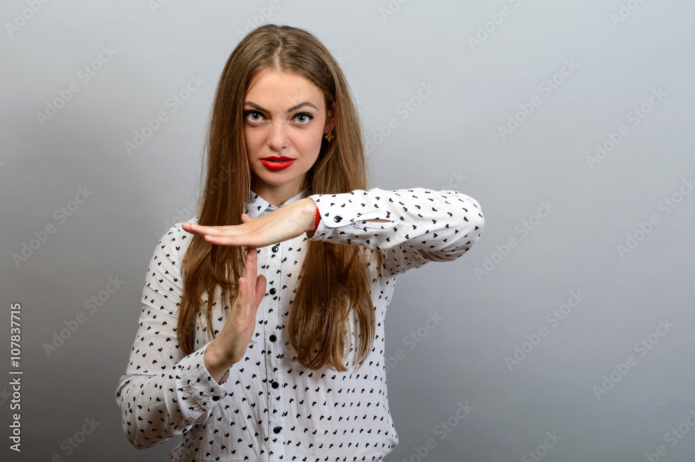 Young woman with a little smile showing time out hand gesture, isolated ...