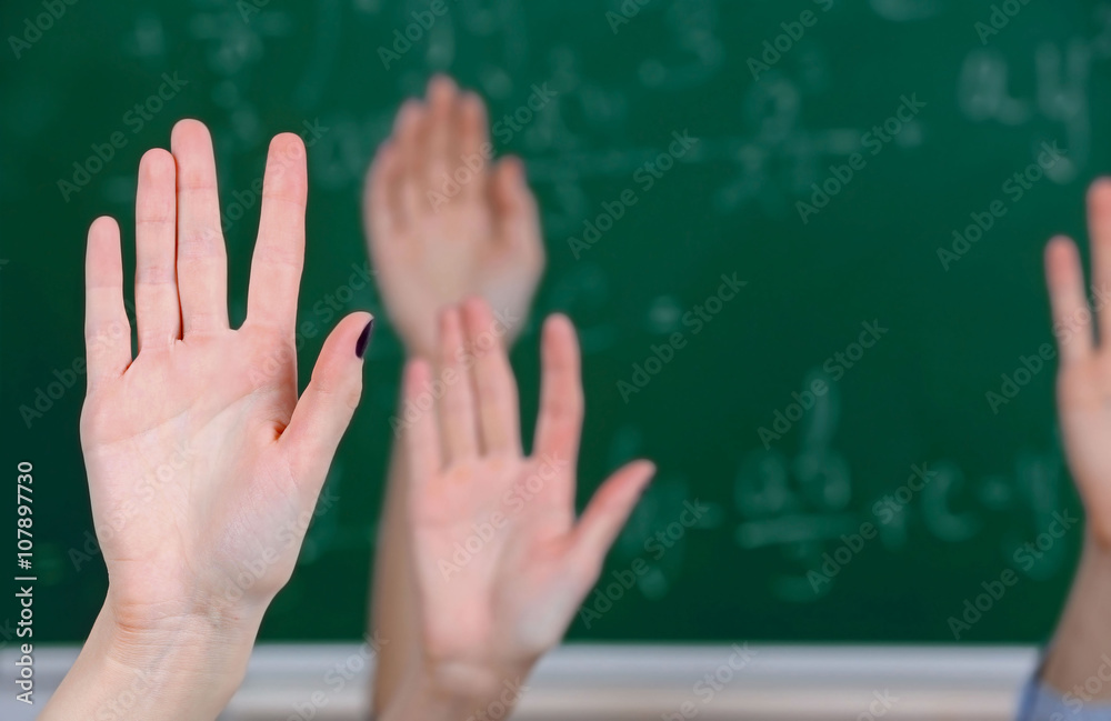 Raised hands on blackboard background in class Stock Photo | Adobe Stock