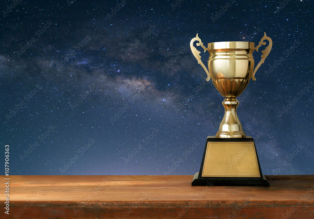 champion golden trophy on wood table with Milky Way background Stock ...
