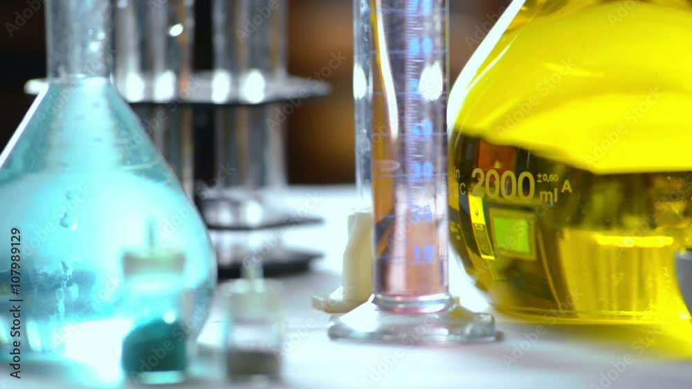 Flasks with yellow and blue reagents, test tubes and beakers in a ...