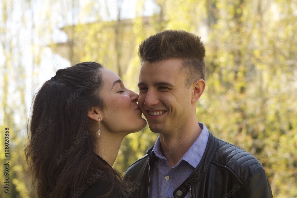 Beautiful girl kissing boy on the cheek Stock Photo | Adobe Stock