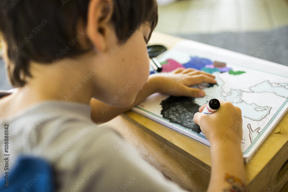 Mixed race boy coloring map with crayon Stock Photo | Adobe Stock