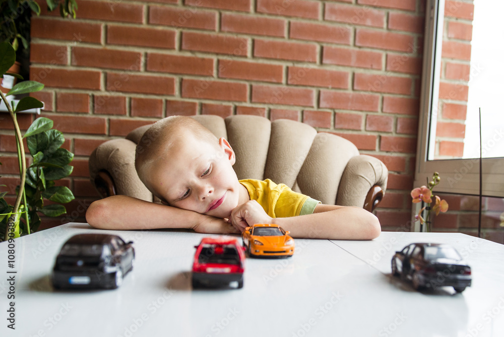 Caucasian boy playing with toy cars at desk Stock Photo | Adobe Stock