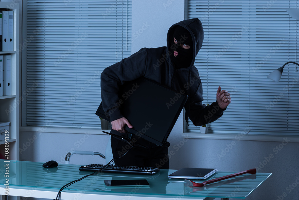 Thief Stealing Computer From Office foto de Stock | Adobe Stock
