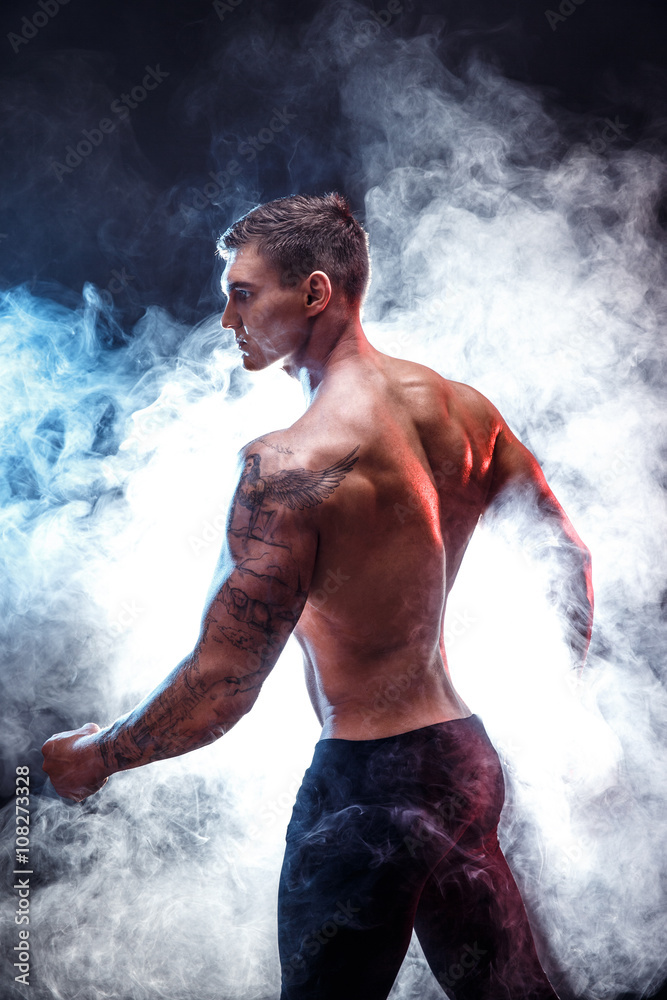 Handsome power athletic man bodybuilder. Fitness muscular body on dark ...