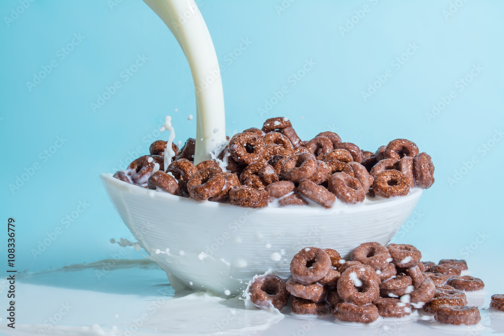 Milk stream jet pouring into a bowl with chocolate flakes in the form ...