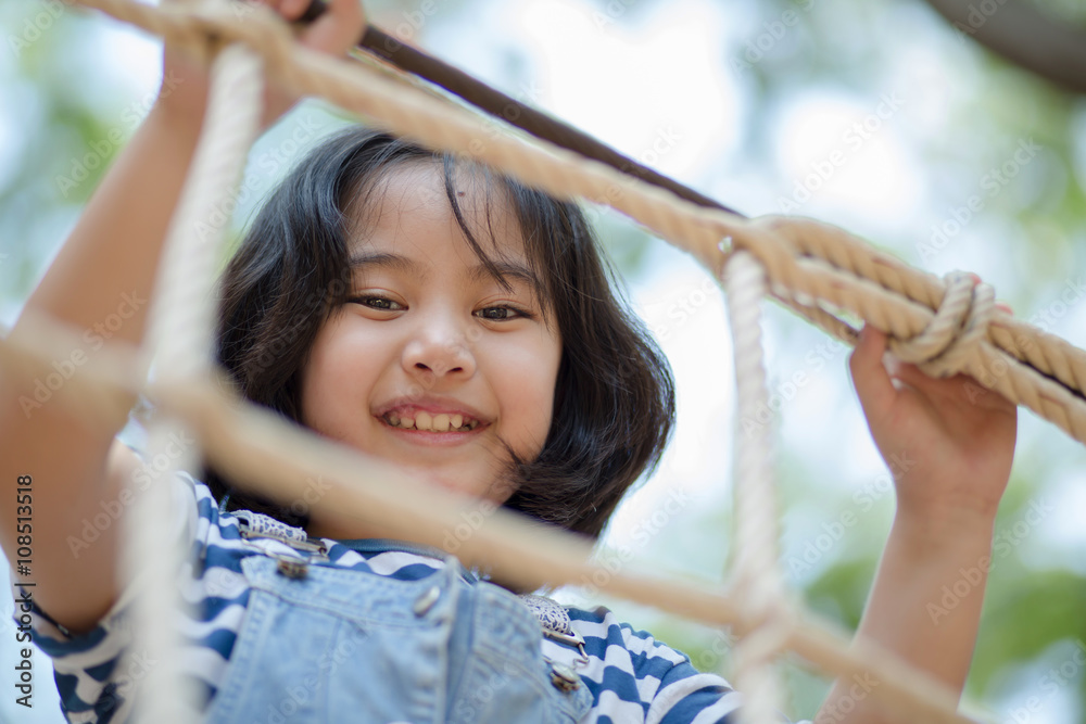Cute children. Asian girl climbing in a rope playground structure at ...