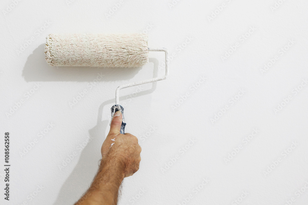 hand painter man at work with a paint roller, wall painting concept ...