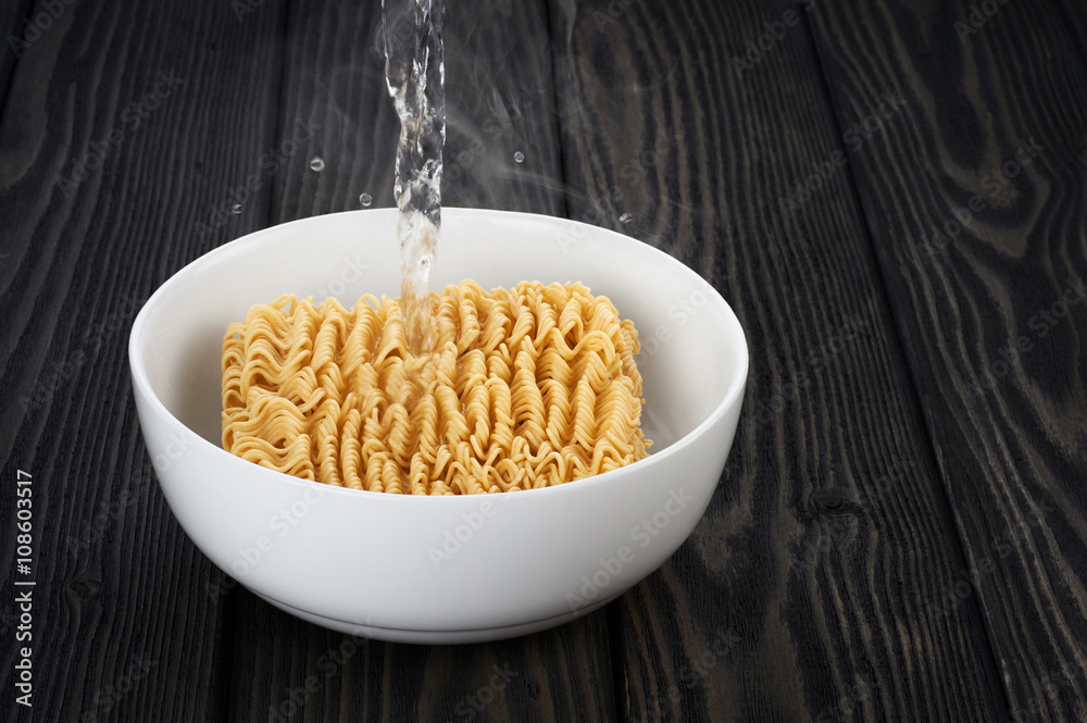 Cooking instant noodles, pouring boiling water. Stock Photo | Adobe Stock