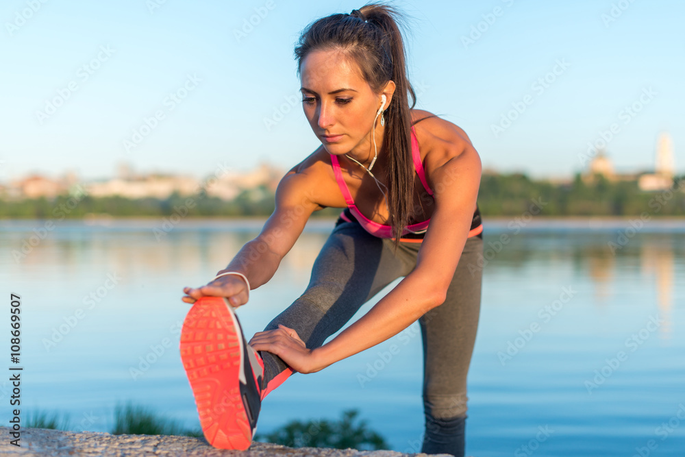 Fitness model athlete girl warm up stretching her hamstrings, leg and ...