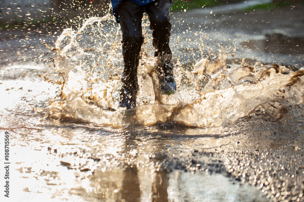 Little boy splashing in a mud puddle, jumping into a puddle Stock Photo ...