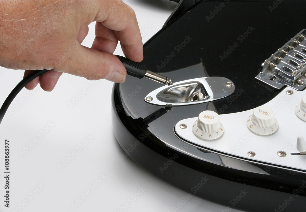 Inserting a cable plug in an electric guitar Stock Photo | Adobe Stock