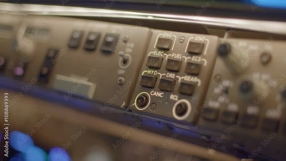 Detail of African-American pilot's hand pressing buttons on a panel in ...