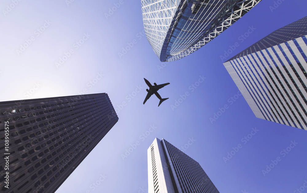 Airplane flys between tall city buildings Stock Photo | Adobe Stock