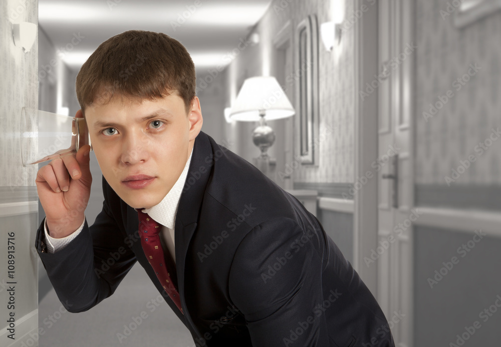 Businessman spying by listening through wall with glass Stock Photo ...