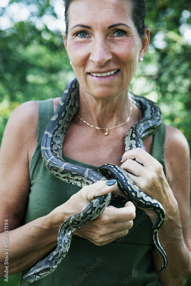 Mature woman with snake around neck Stock Photo | Adobe Stock