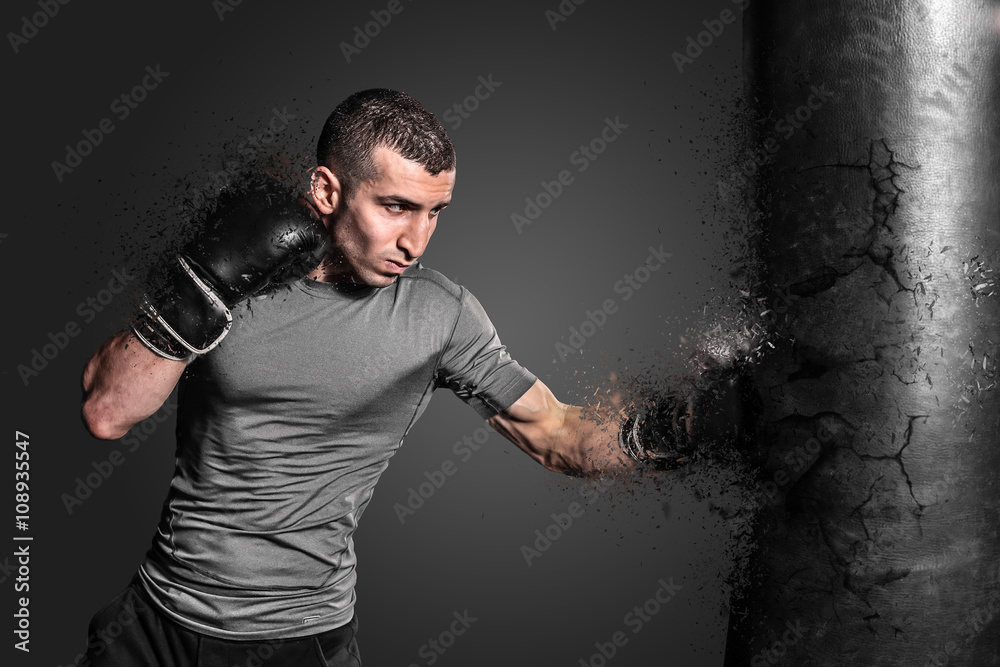 Boxer punching bag blow to the explosion. Young sportsman in black ...
