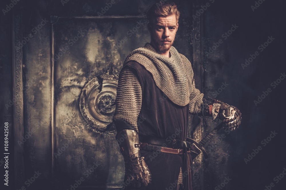 Young medieval knight standing on dark background. Stock Photo | Adobe ...