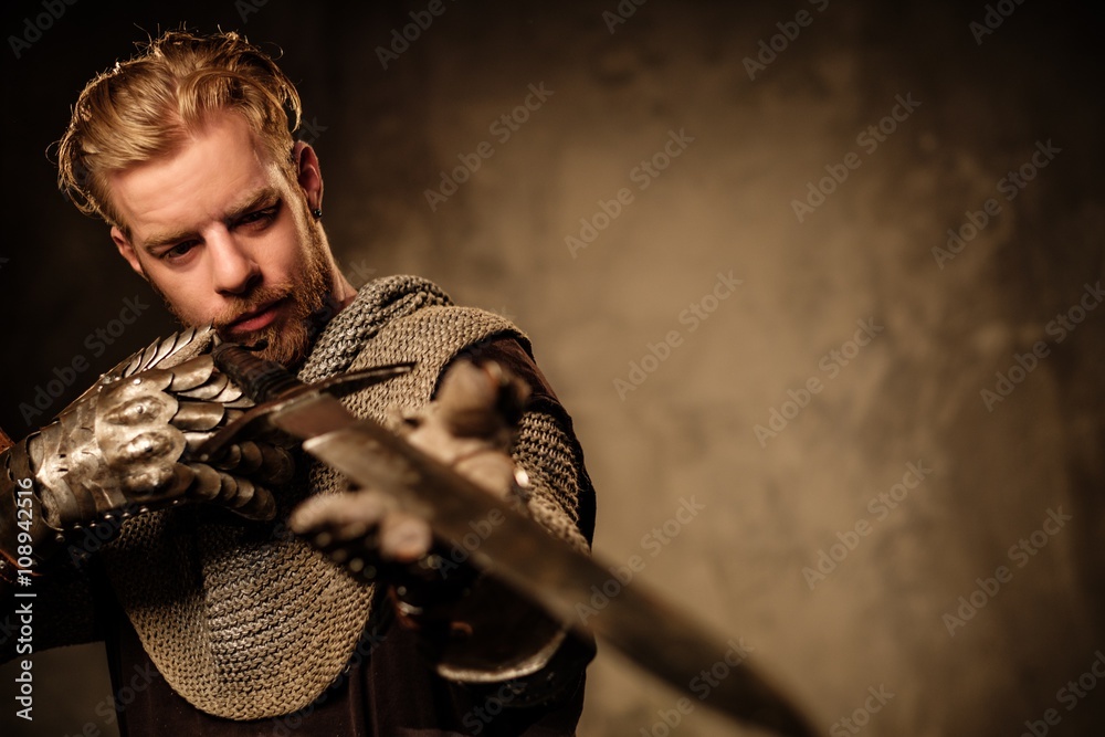 Young medieval knight posing on dark background. Stock Photo | Adobe Stock