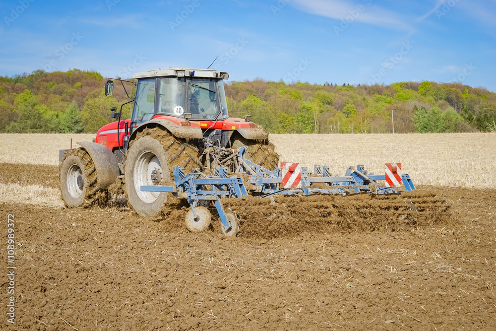 Traktor mit Egge bei der Bodenbearbeitung, von hinten Stock Photo | Adobe Stock