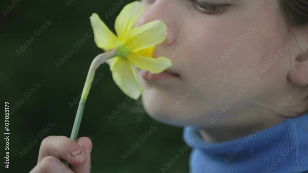 Portrait of a boy in the spring with a flower of yellow narcissus ...