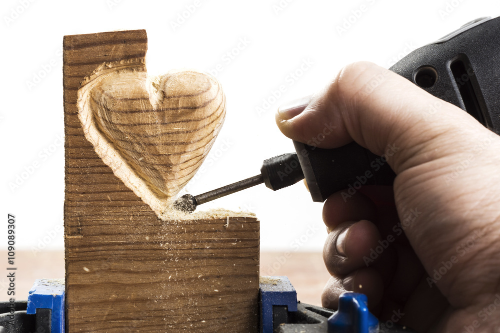 Carving wood in heart shape with rotary tool, on white background Stock ...