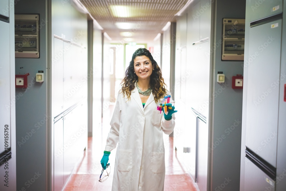 Female scientist walking in laboratory of material science and ...