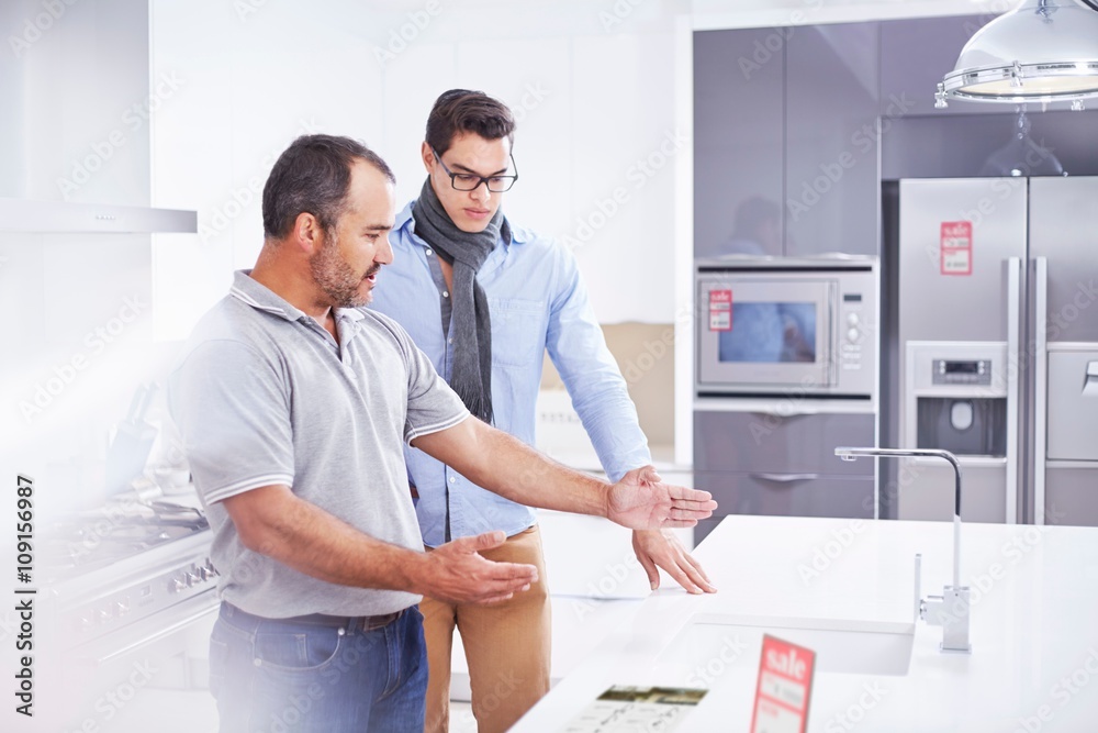 Salesman and young man in kitchen showroom Stock Photo | Adobe Stock