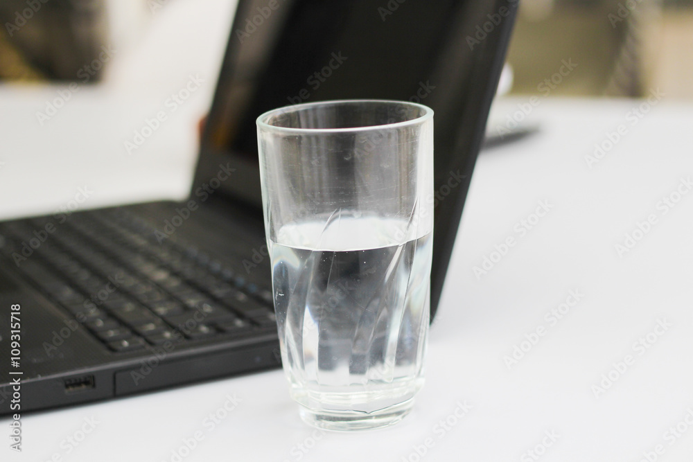 Calculator, laptop and cup of water in a workplace Stock Photo | Adobe ...