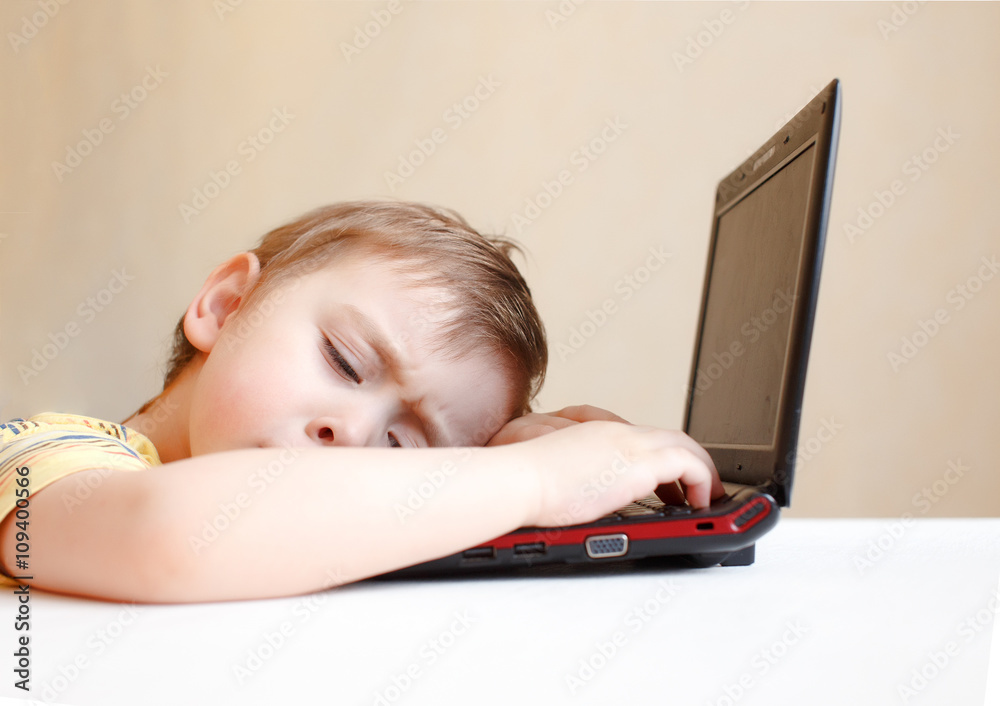 child fell asleep from fatigue in front of computer. little boy ...