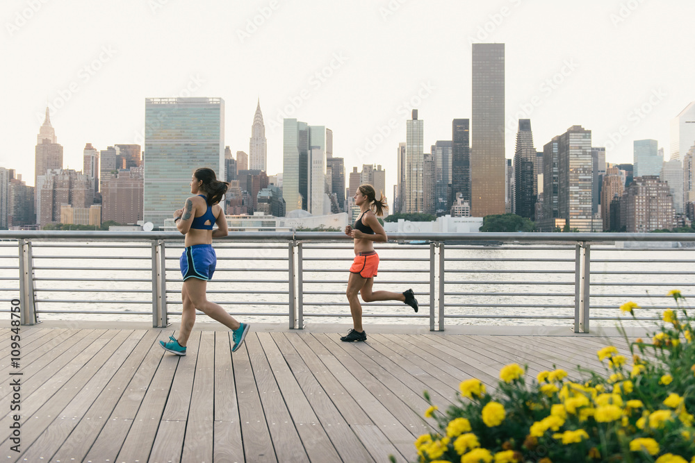 Two friends exercising together, running outdoors by river Stock Photo ...