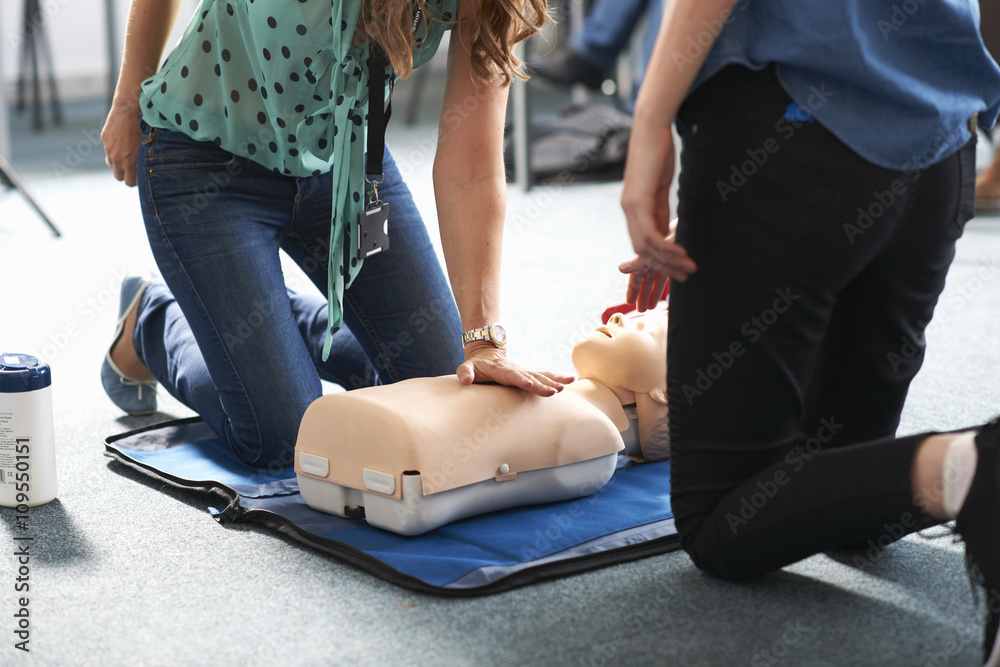 College student performing CPR on mannequin in class Stock Photo ...