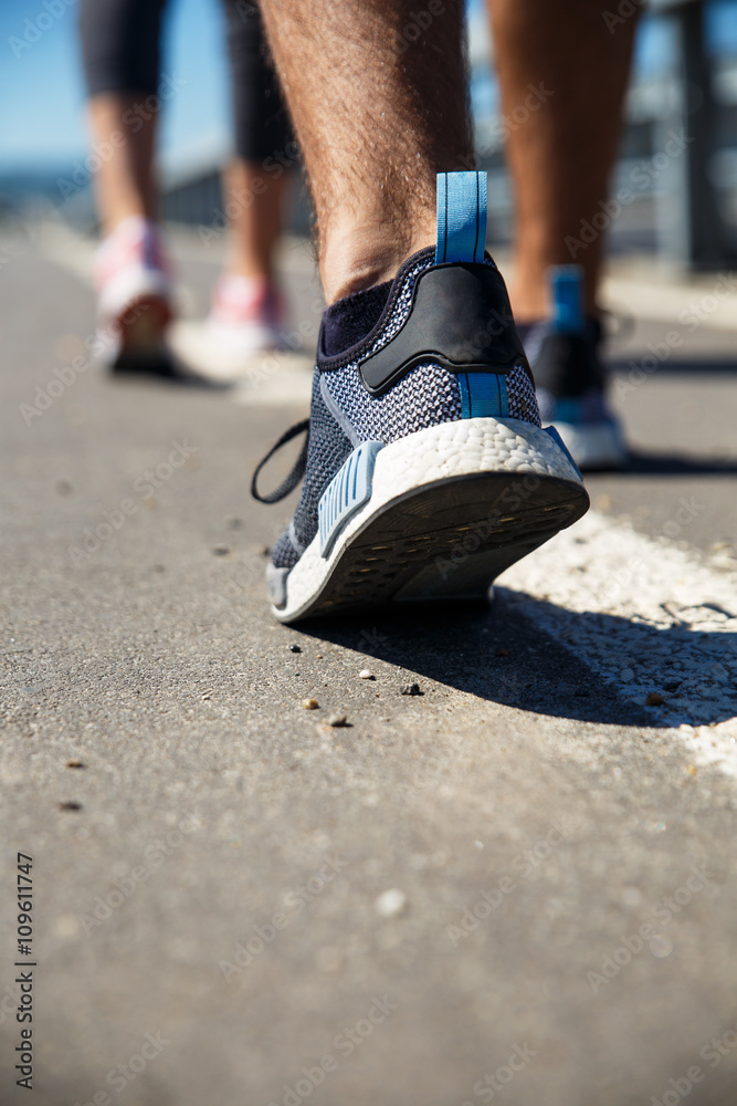Feet of an athlete couple running on a pathway training for fitness and ...