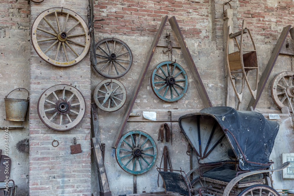 Hanging wheels in a farm and an old curricle Stock Photo | Adobe Stock