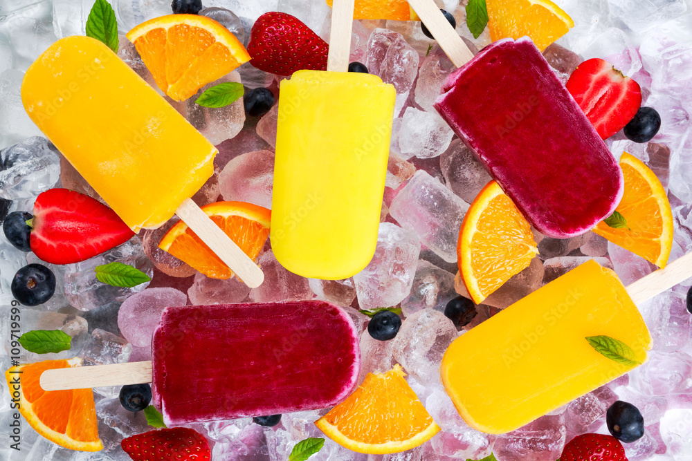 refreshing fruit popsicle lollies on ice background with berries ...