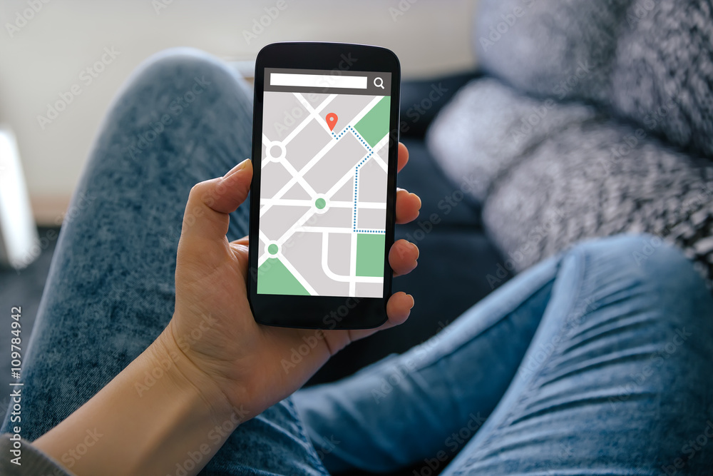 Girl holding smart phone with map gps navigation application on screen. All screen content is ...