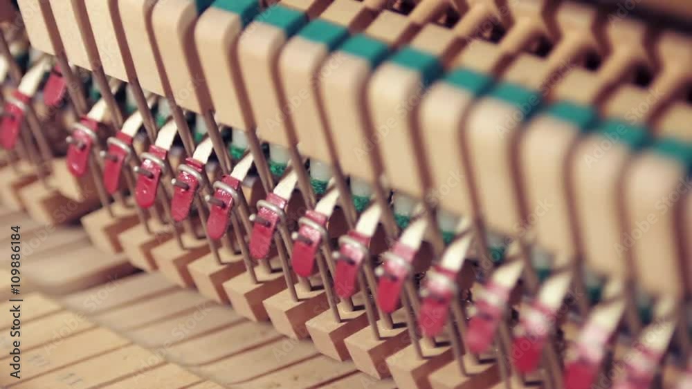 Piano mechanics in action exposed on upright piano, close-up with rack ...