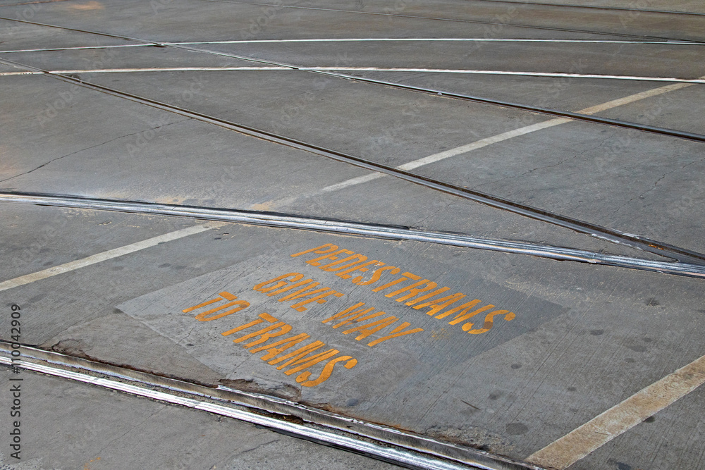 Closeup of tramway with yellow signage “Pedestrians give way to trams ...