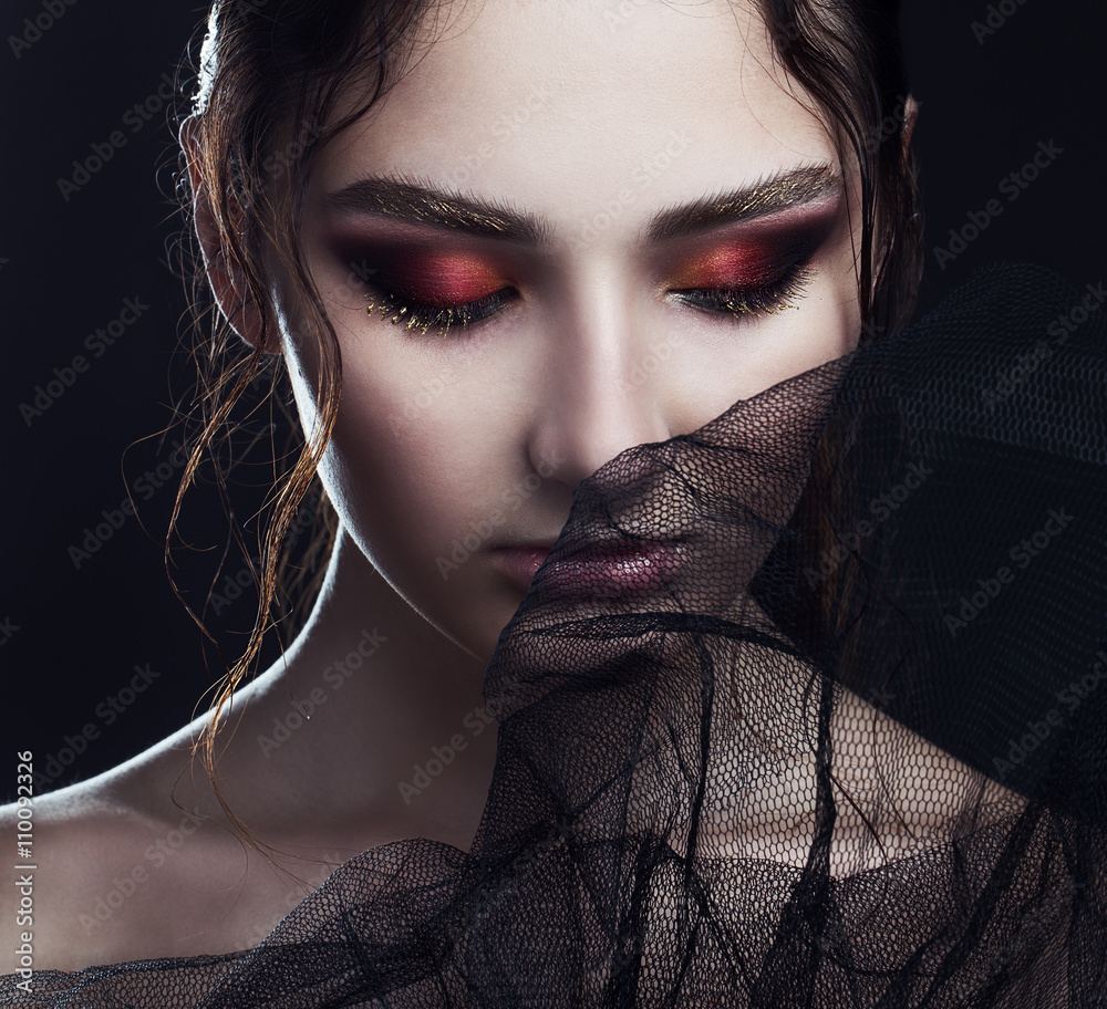 Portrait Of Mysterious Beautiful Brunette Through Black Veil And Posing Over Black Background