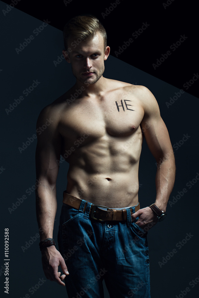 Handsome muscular male model with intense glance posing over grey ...