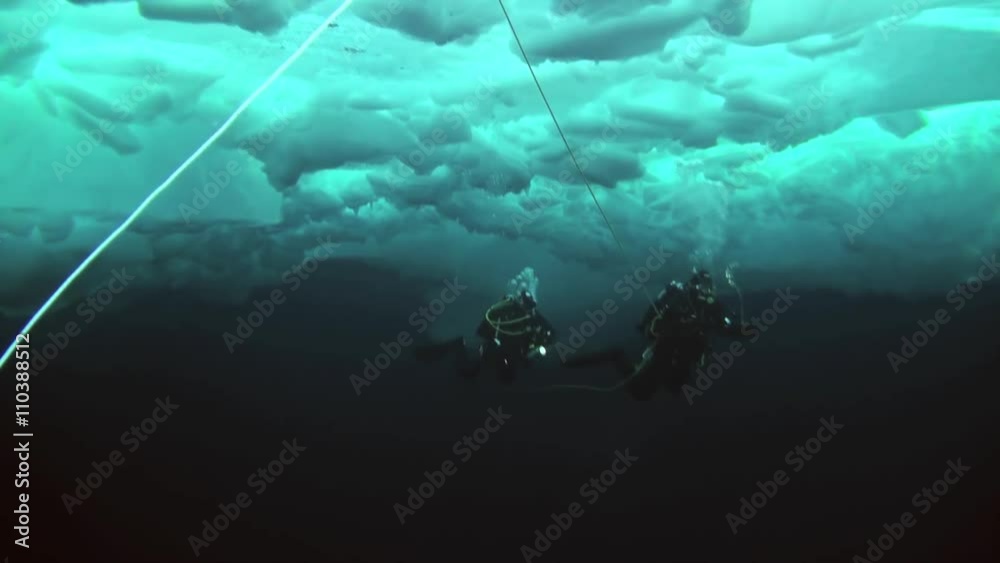 Vidéo Stock Unique extreme underwater shooting scuba dive beneath ice ...