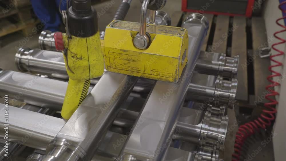 The CNC machine magnets two metal tubes ready to be carried and ...