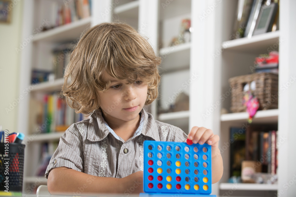 Litlle boy playing four in a row. Growing child's brain, cognitive and ...