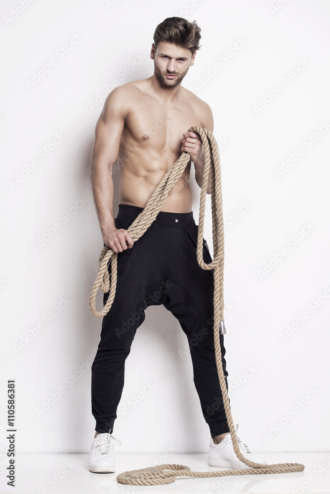 Handsome and muscular man holding a rope in his hand Stock-Foto | Adobe ...