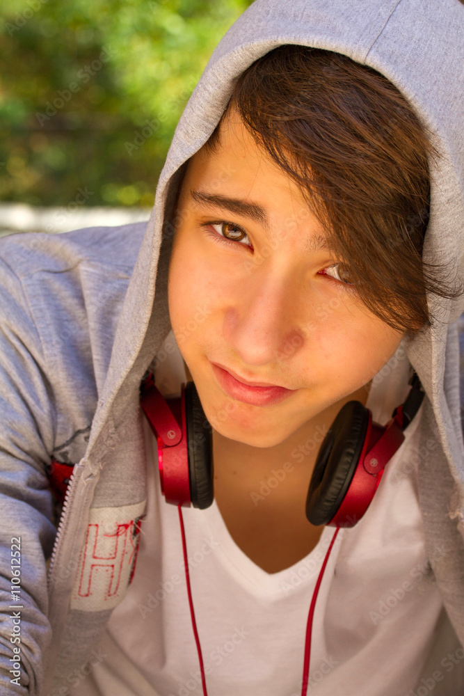 Outside portrait of teen boy. Handsome teenager smiling and sitting on ...
